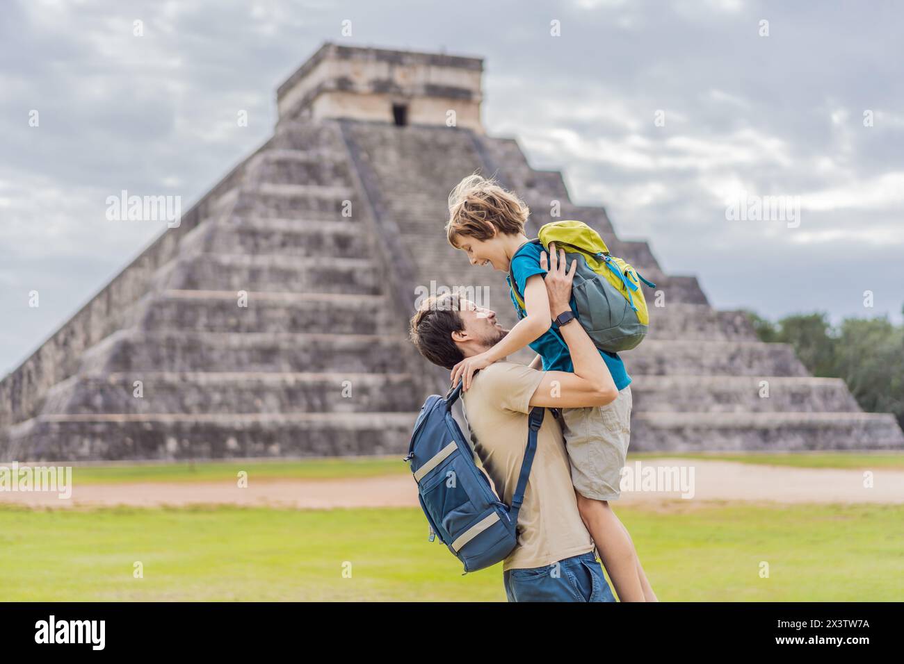 Father and son tourists observing the old pyramid and temple of the ...