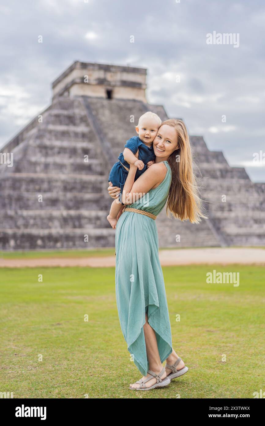 Beautiful tourist woman and her son baby observing the old pyramid and ...