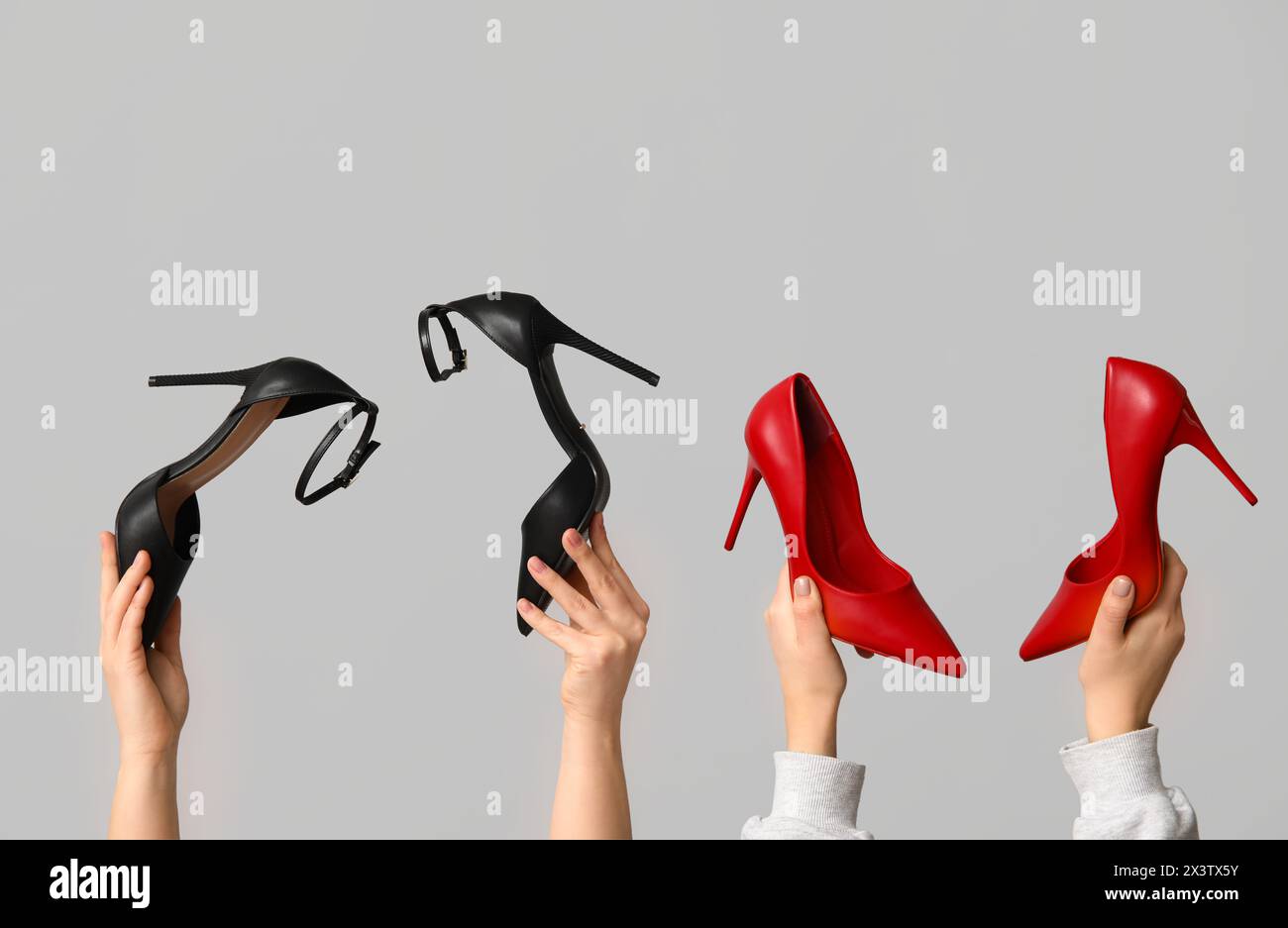 Female hands with different stylish high heels on grey background Stock ...