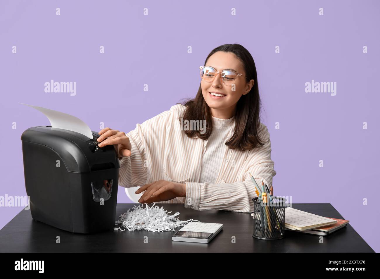 Secretary destroying document in shredder on lilac background Stock ...