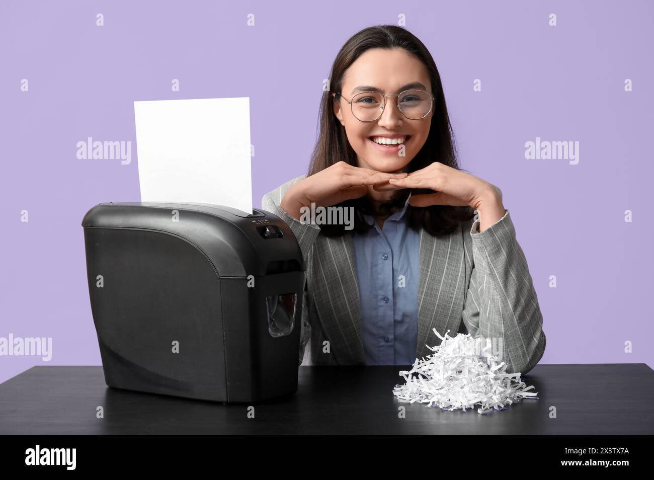Secretary destroying document in shredder on lilac background Stock ...