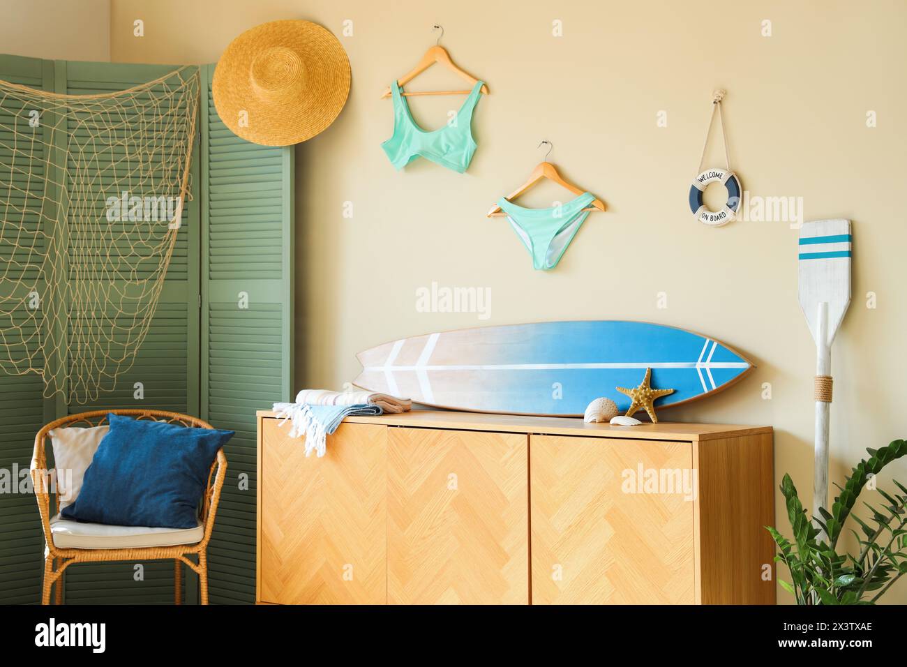 Interior of living room with surfboard, paddle and bikini. Summer ...