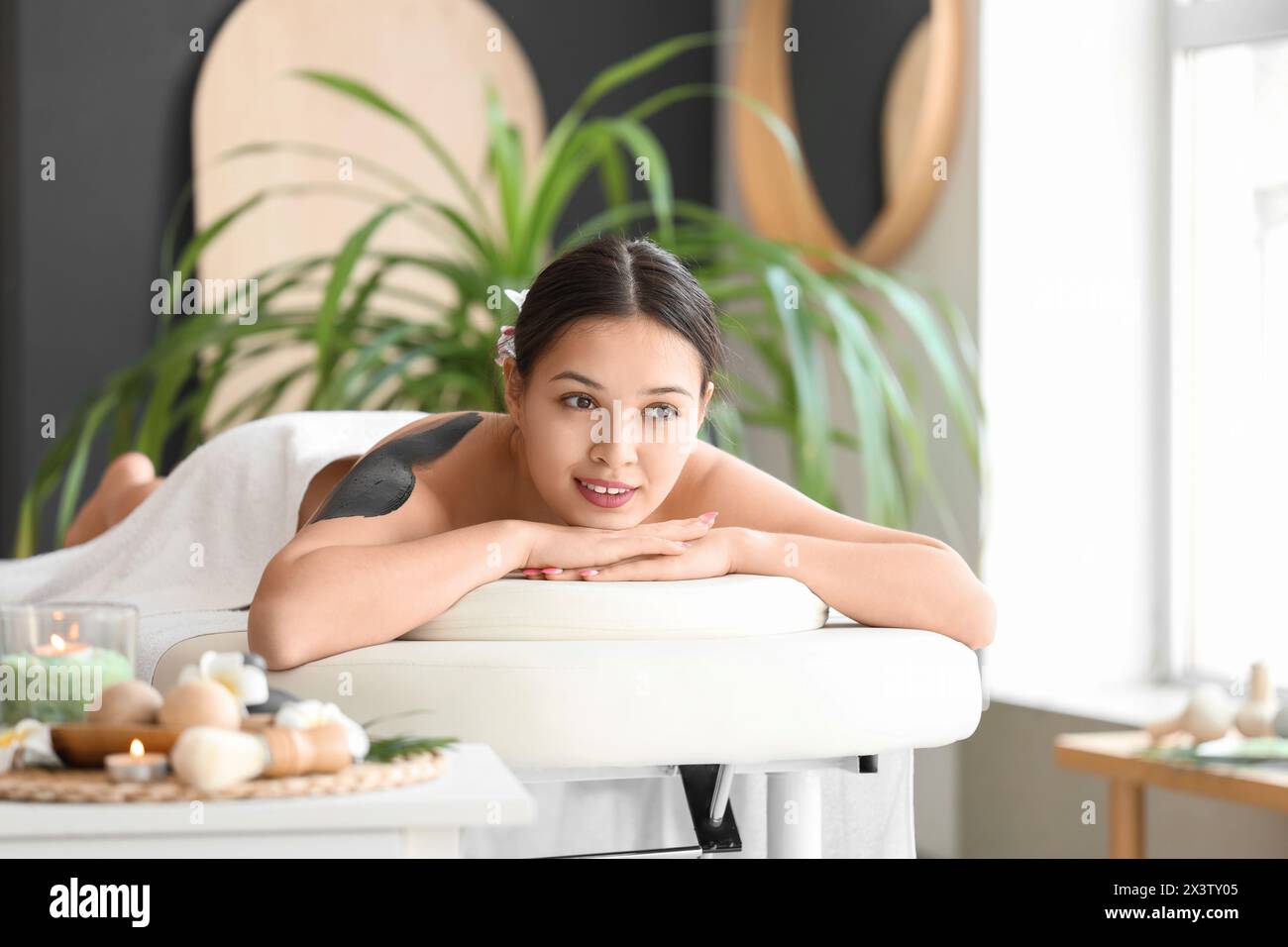 Beautiful Asian woman with mud on her shoulder lying in spa salon Stock ...