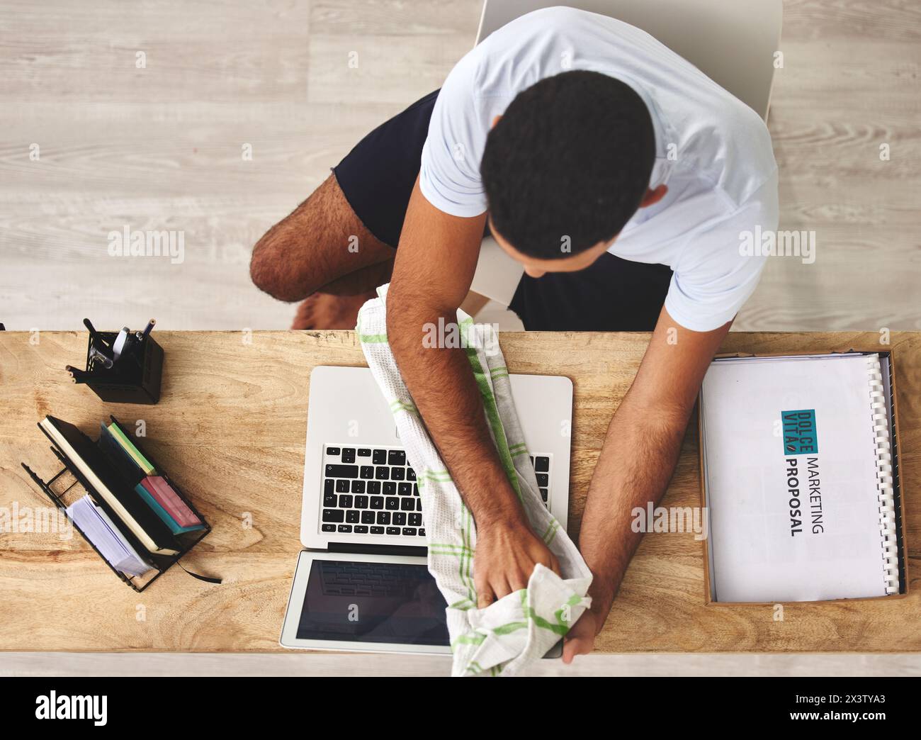 Remote work, home and man with cleaning of laptop on desk for hygiene ...