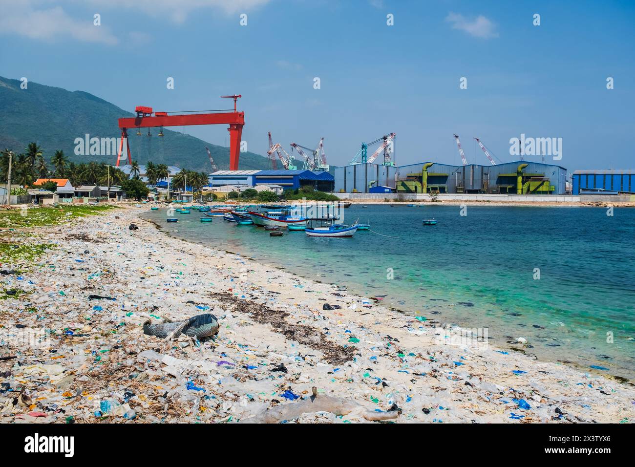 Spilled garbage on beach of big city. Empty used dirty plastic bottles ...