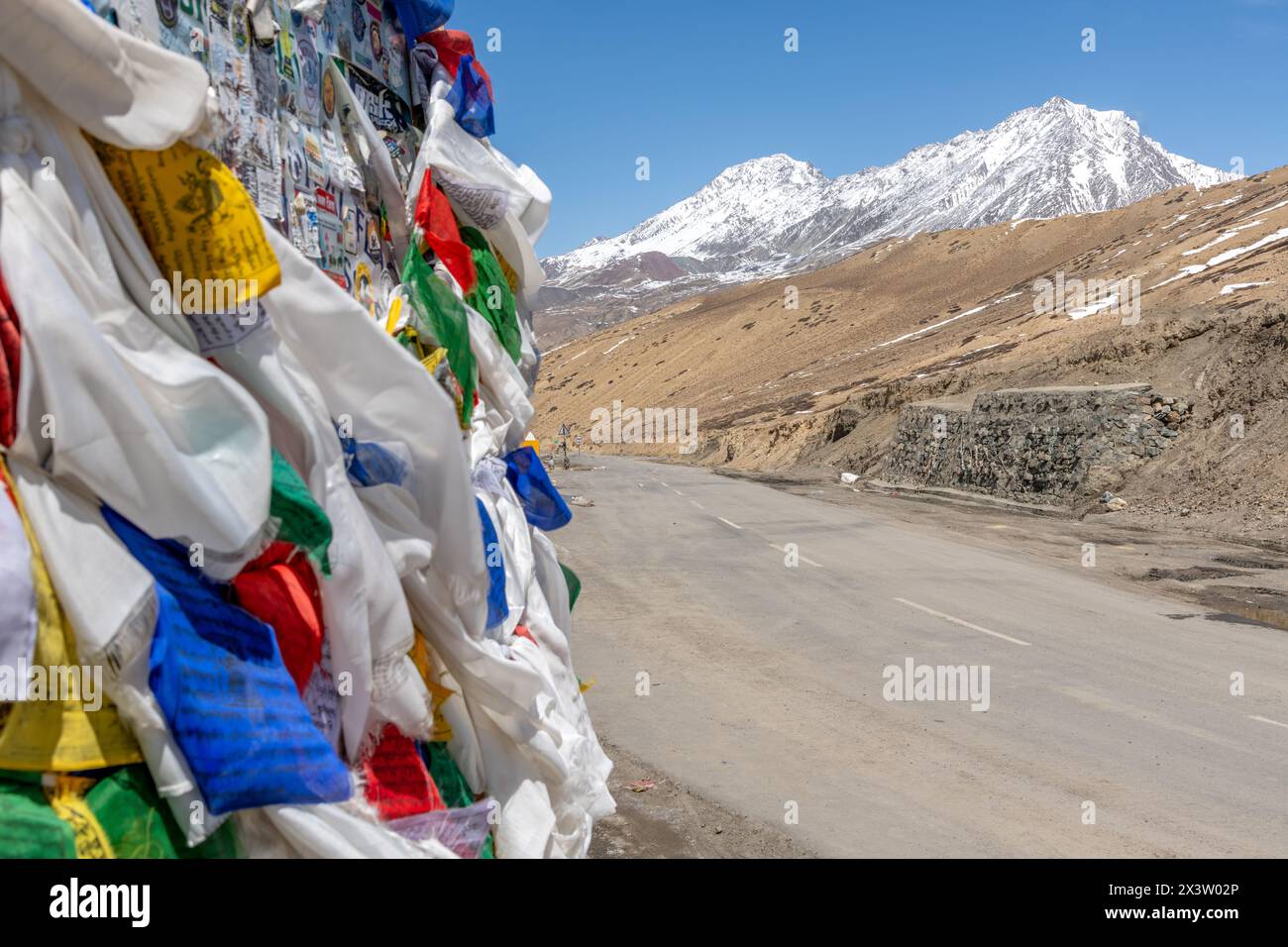 Colorful prayer flags alongside a high mountain road in the northern ...