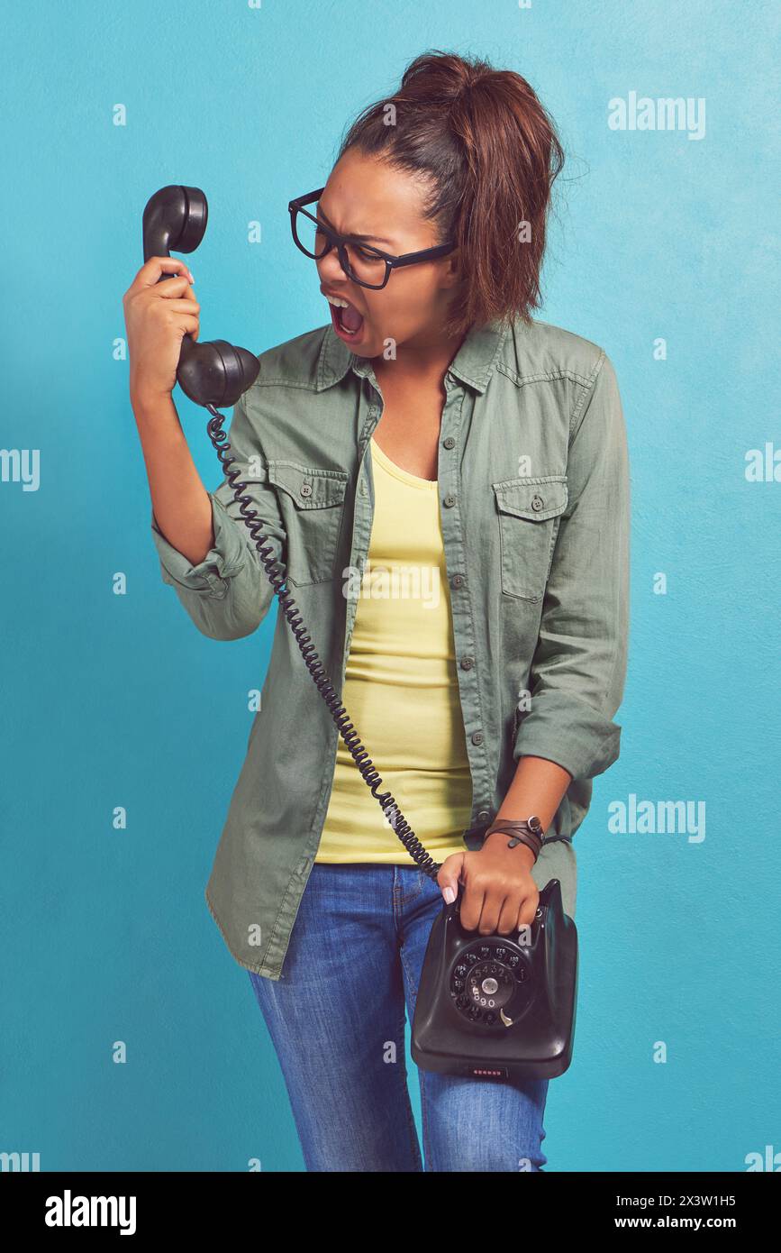 Telephone, angry and shouting with woman, stress and frustrated on blue ...