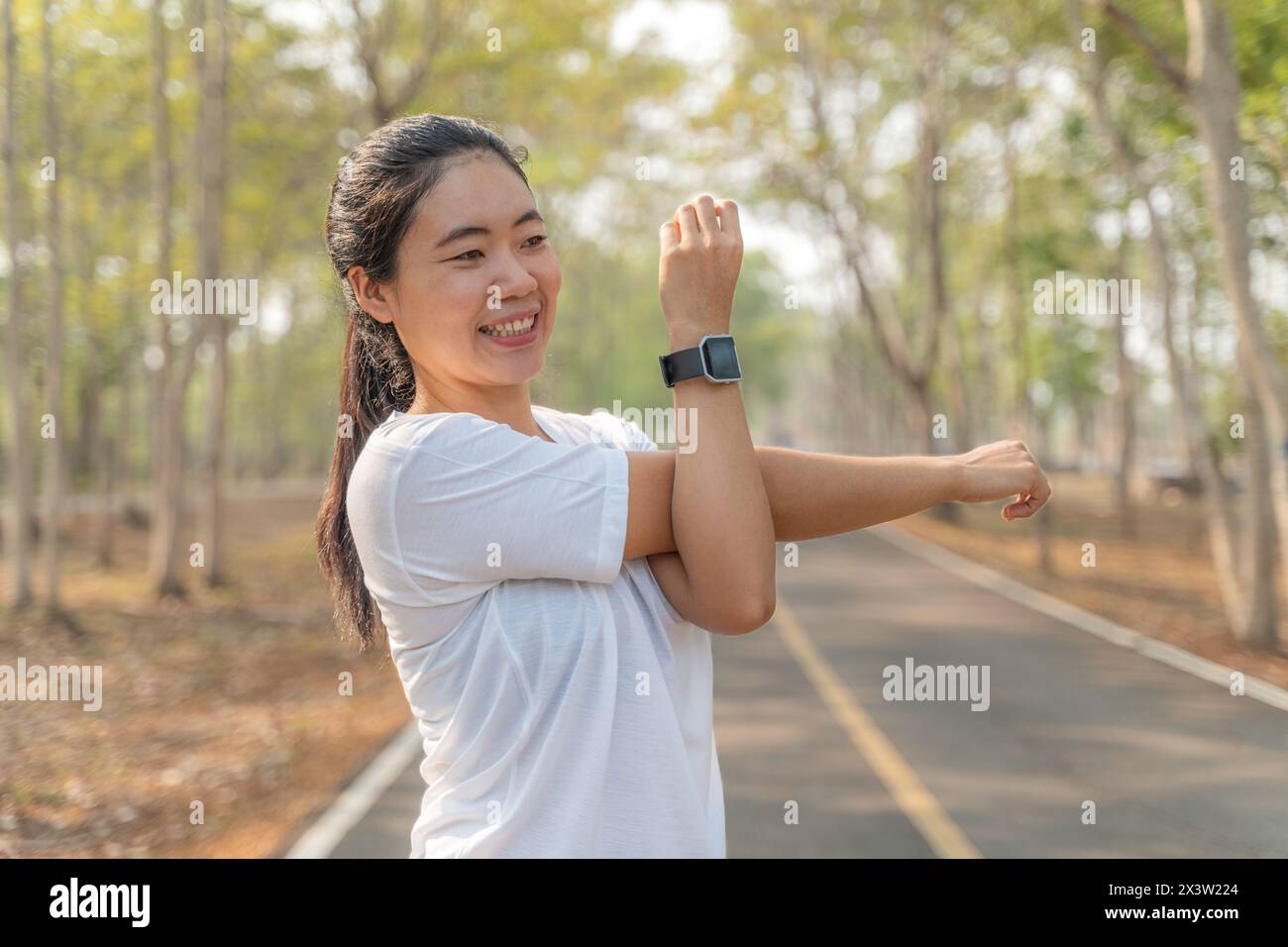 Young female runner stretching her arms and legs before starting her ...