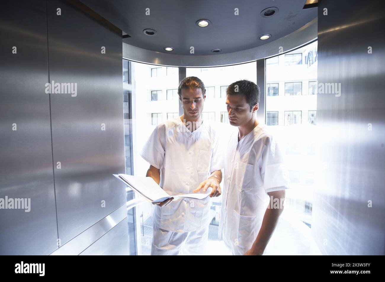 Doctors in lift Stock Photo - Alamy