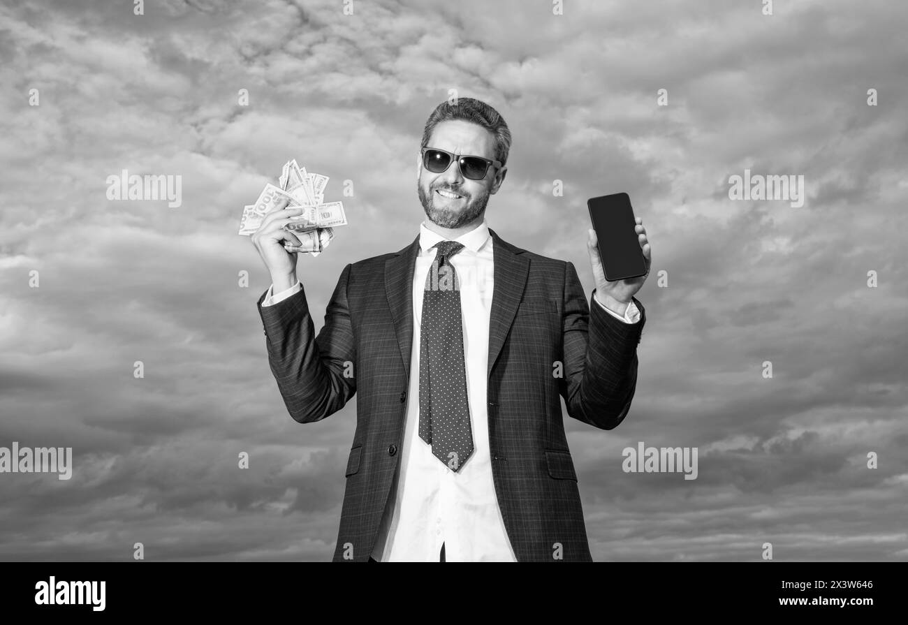 Happy rich man businessman holding cash money and smartphone. Money ...