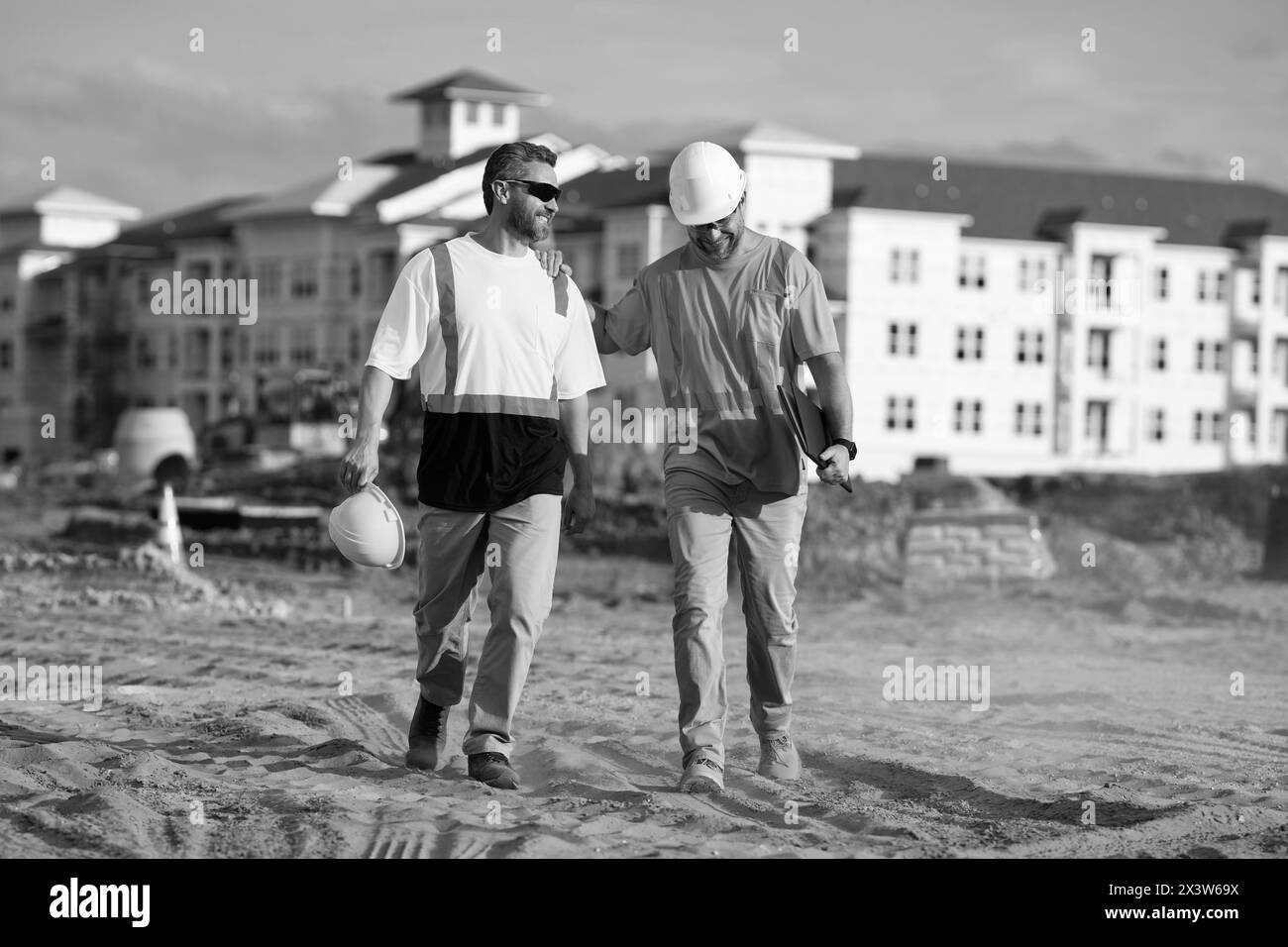Construction workers working at construction site. Men wearing safety ...