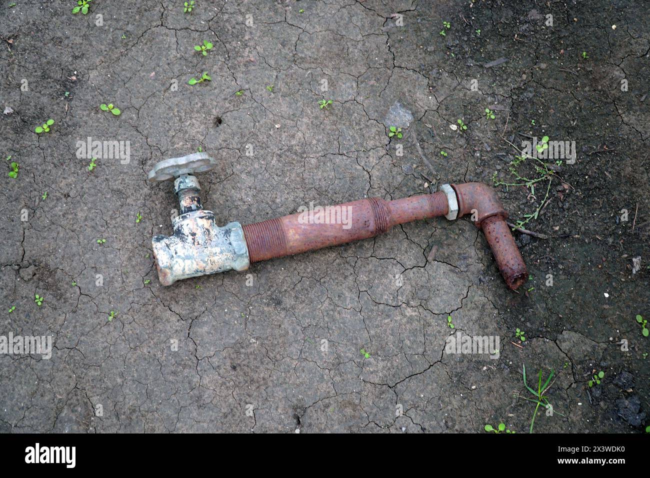 A fragment of an old rusty pipe with a tap on the ground Stock Photo ...