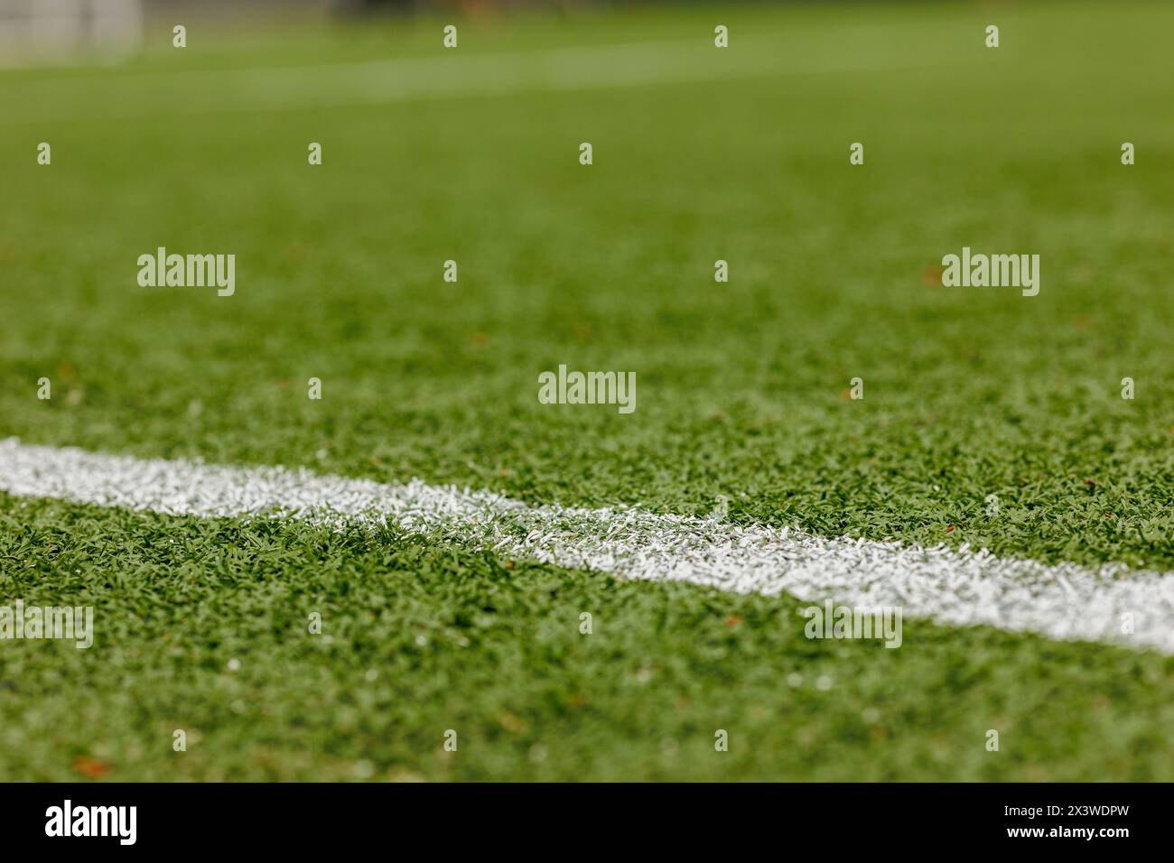Green synthetic grass sports field with white diagonal line from above ...