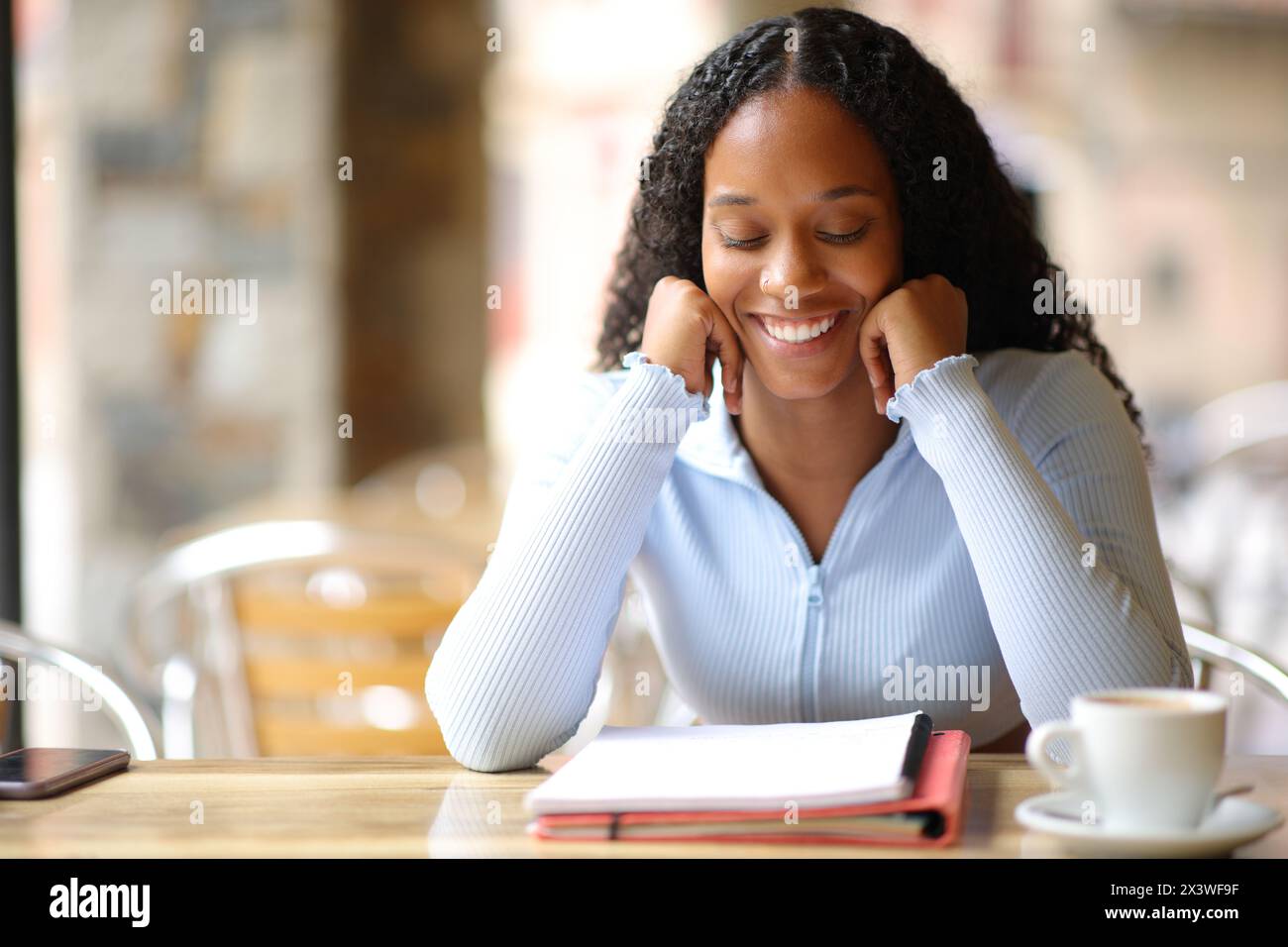 Front view portrait of a happy black student memorizing notes in a bar ...