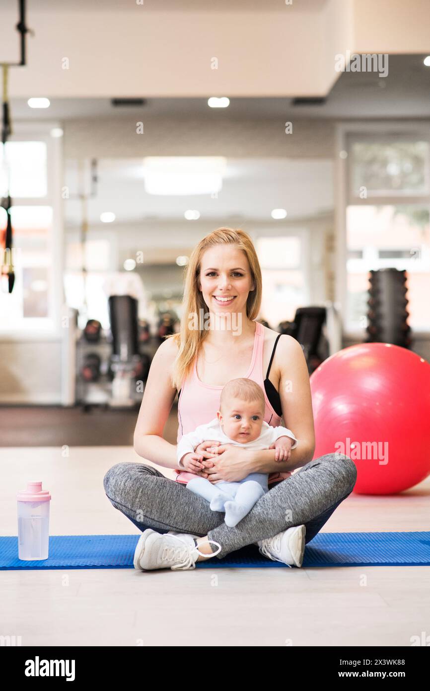 Portrait of new mom on group exercise class in gym. Moms staying active ...