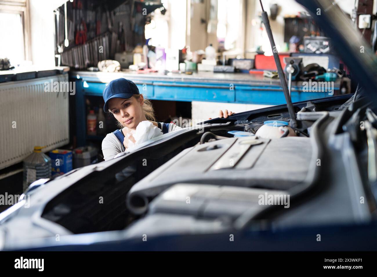 Female auto mechanic repairing, maintaining car. Beautiful woman ...