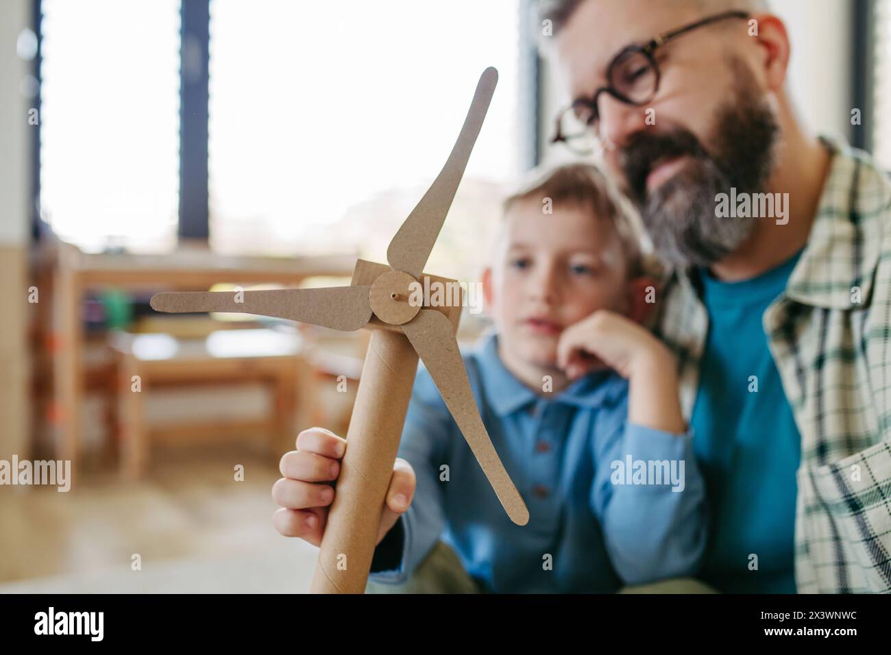 Son and father holding wind turbine model. Concpet of renewable energy ...