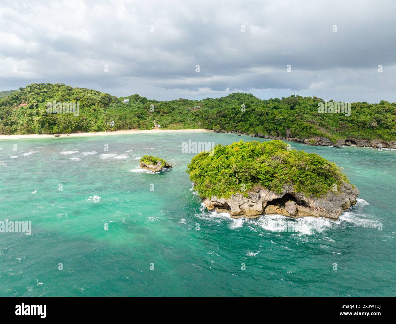 Islets with ocean waves. Ilig Iligan Beach. Blue sky and clouds ...