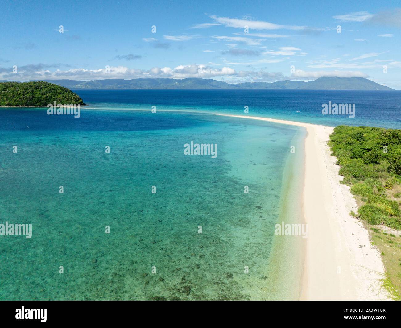 Bon Bon Beach with transparent sea water and waves. Blue sky and clouds ...