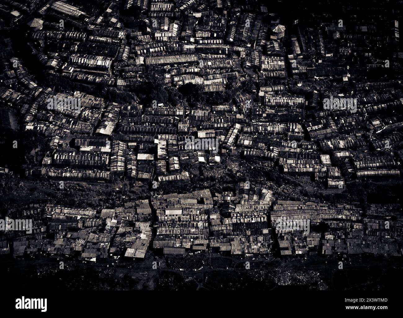 An aerial image in black and white shows the tin shacks of the Kibera ...