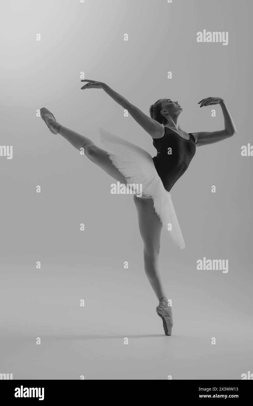 Young ballerina in elegance white tutu and pointe shoes performing ...