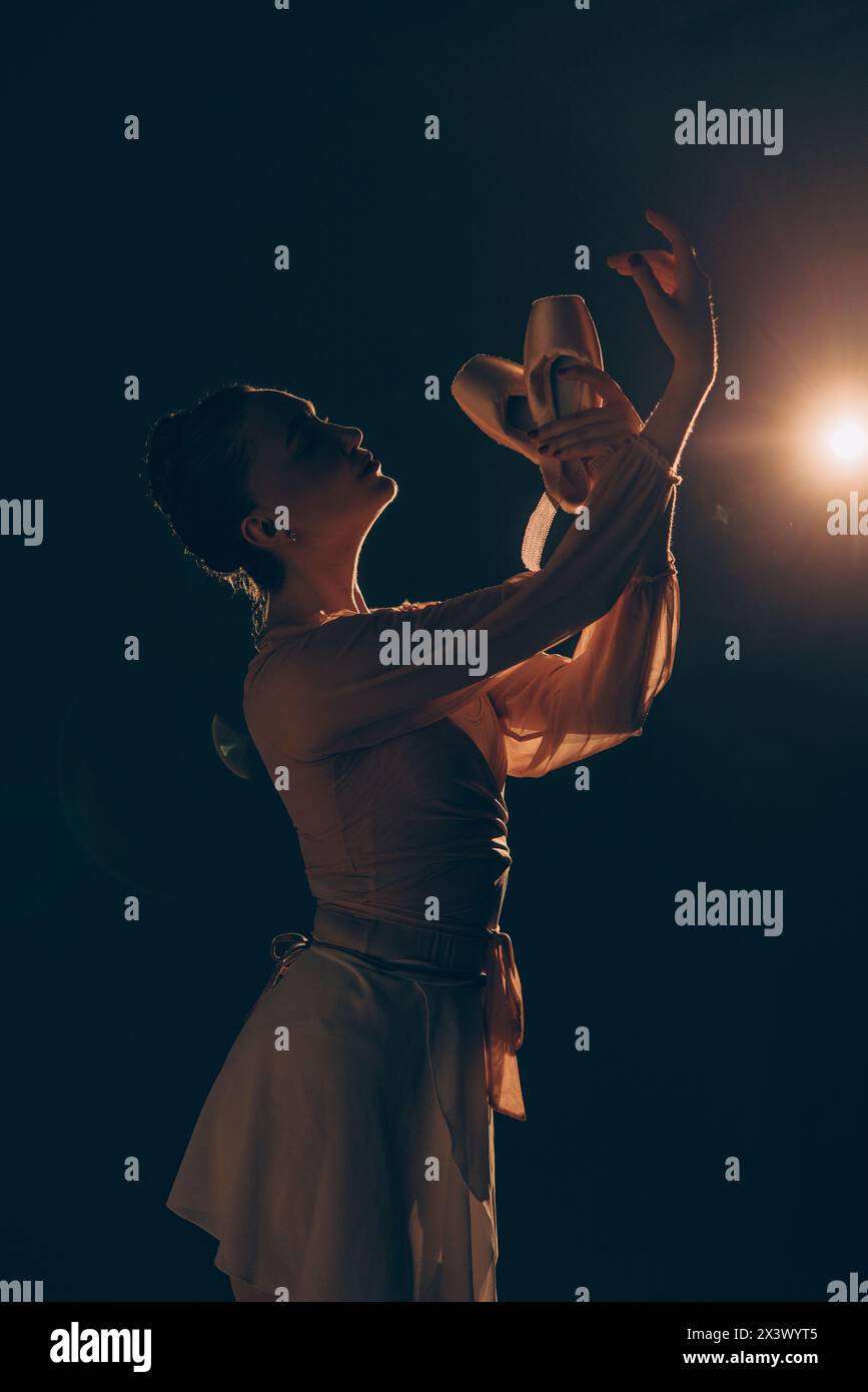 Closeup view to young ballerina holding pointe shoes in her hands on ...