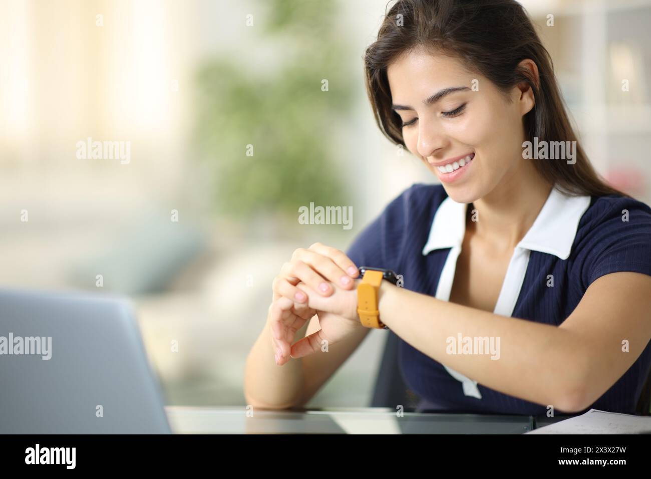 Happy woman checking smartwatch content sitting at home Stock Photo - Alamy