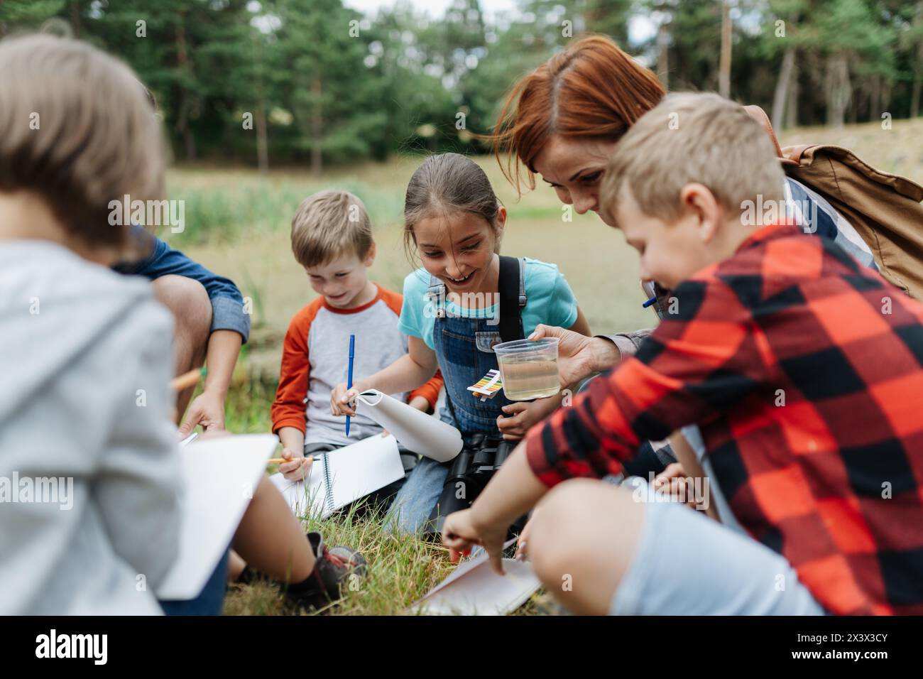 Young students analyzing water quality, ph level with indicator strips ...