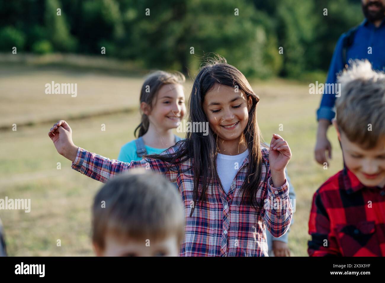 Young students walking across meadow during biology field teaching ...