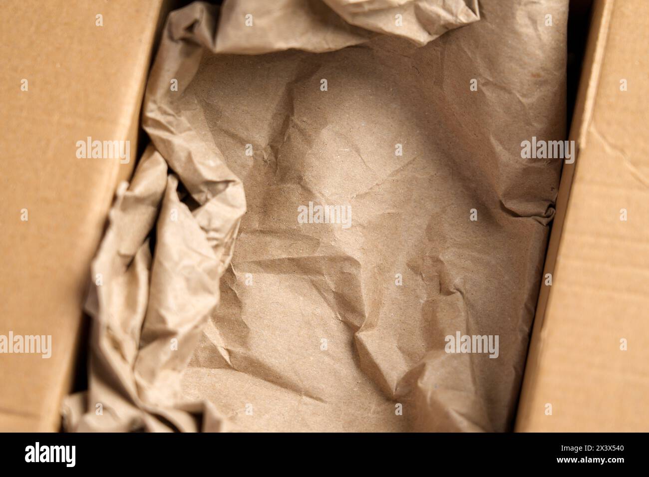 Post cardboard box with crumpled brown paper filler ready for packaging ...