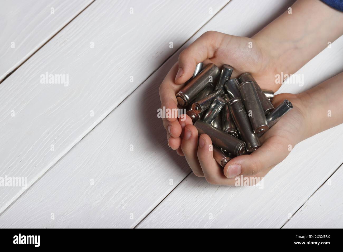 Detailed image of a teenager's hands holding spent finger batteries ...