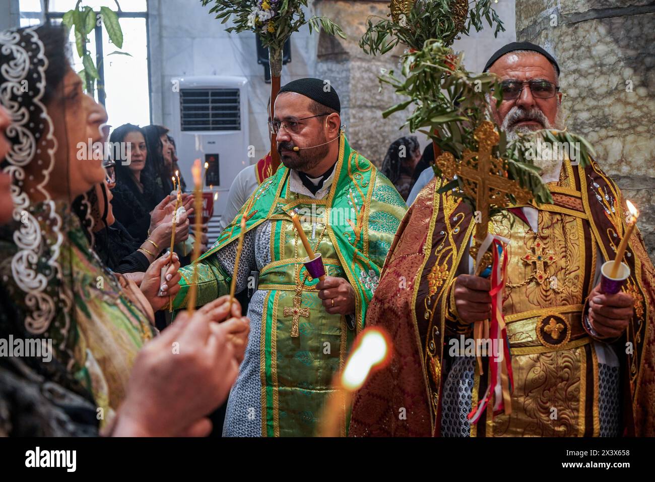 Bartella, Iraq. 28th Apr, 2024. Priests hold the cross during the Palm ...