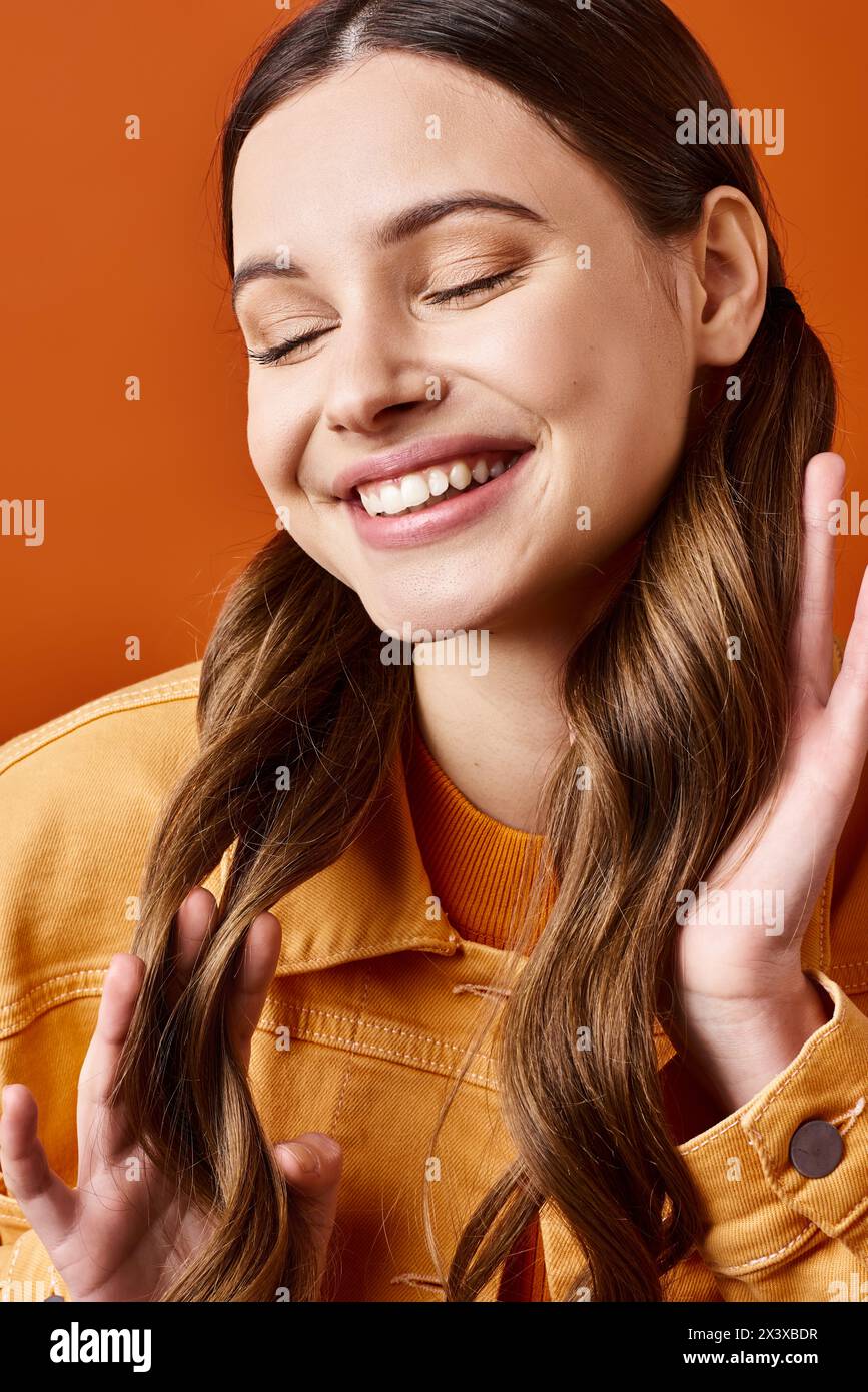 A young, stylish woman in her 20s smiles brightly while holding her ...