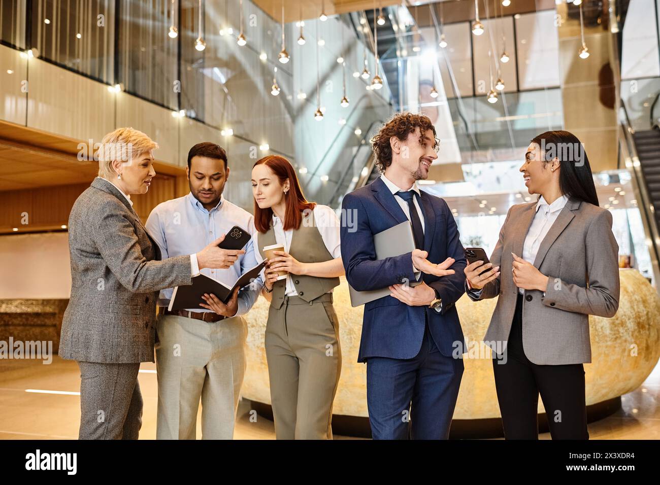 Diverse business team gathers in lobby for conversation and ...