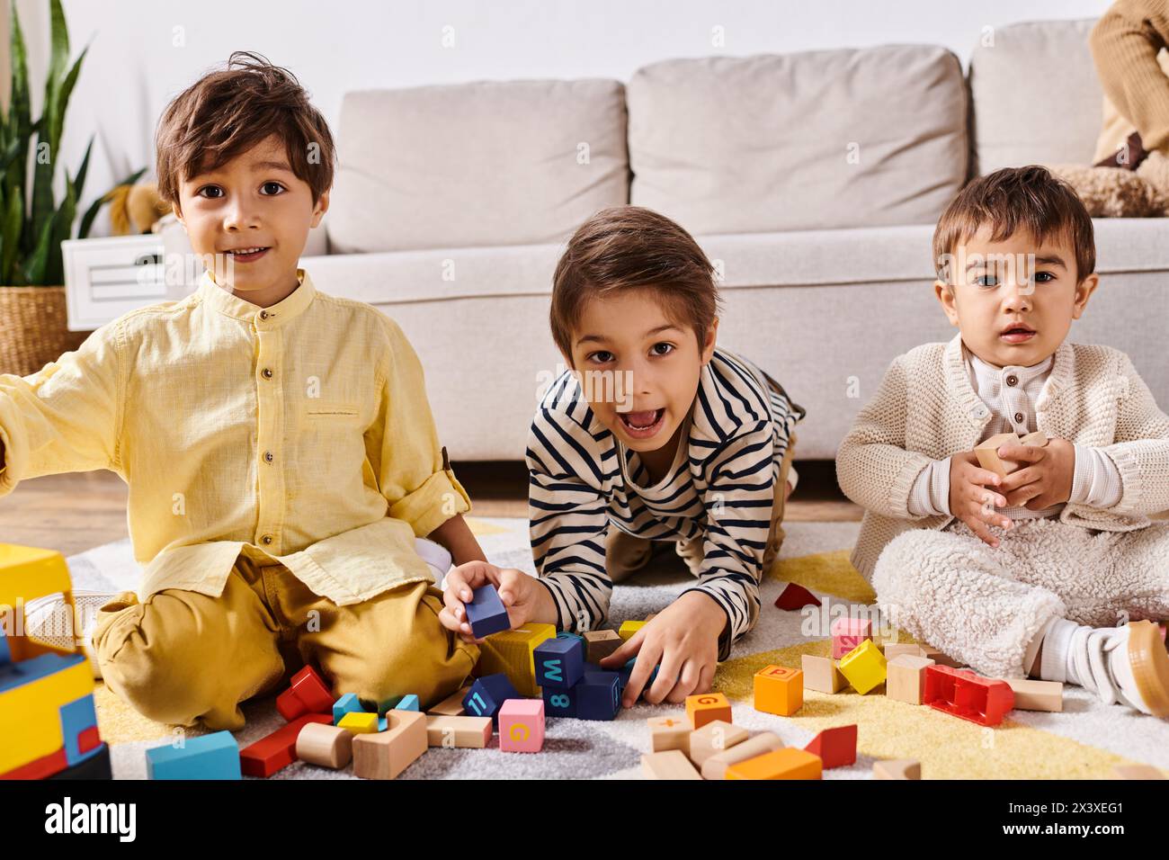 three little asian boys joyfully play and build with blocks on the ...