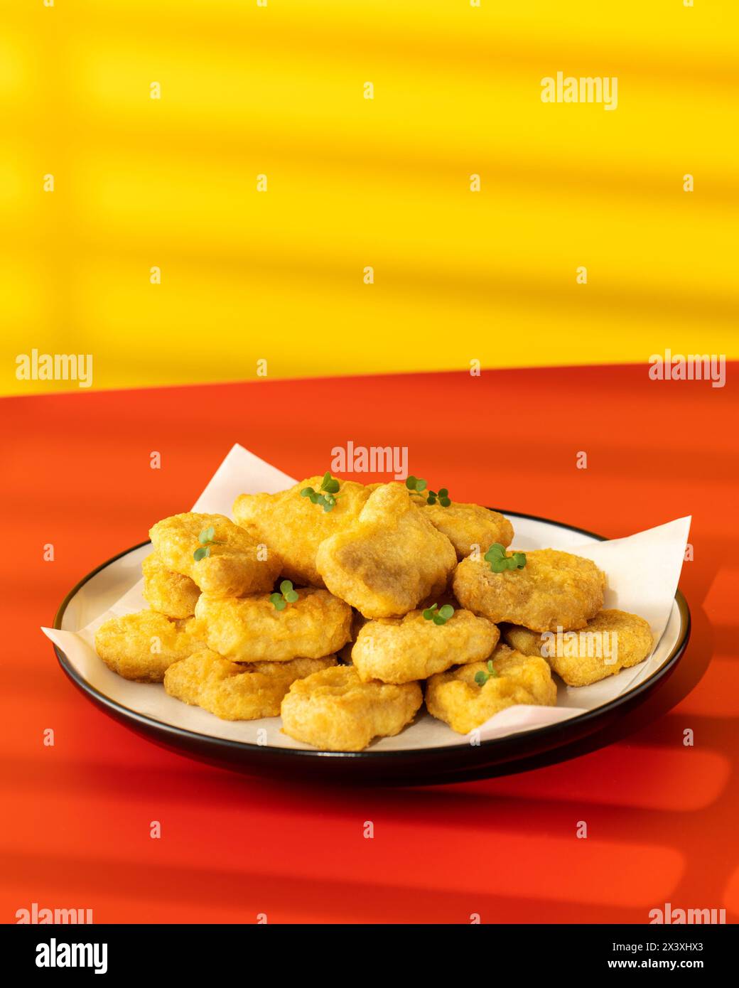Delicious golden chicken nuggets on a plate on the table. Fast food ...