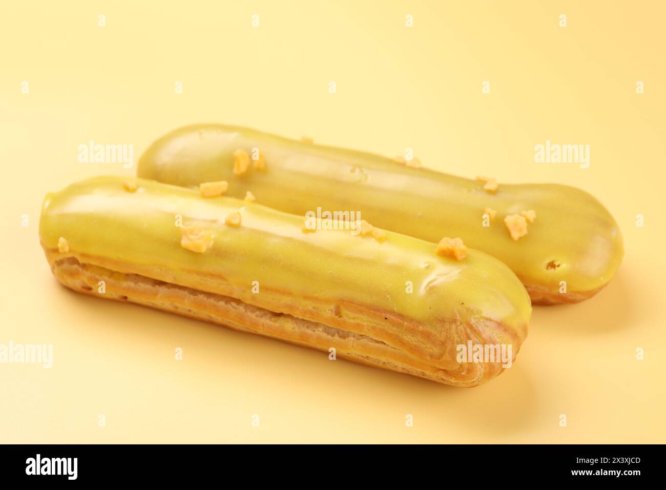 Delicious eclairs covered with glaze on yellow background Stock Photo ...