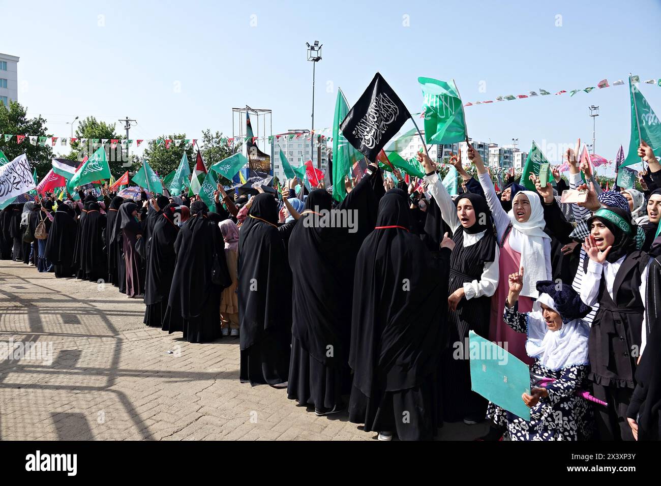 Women carrying Islamic flags and chanting slogans at the event in ...