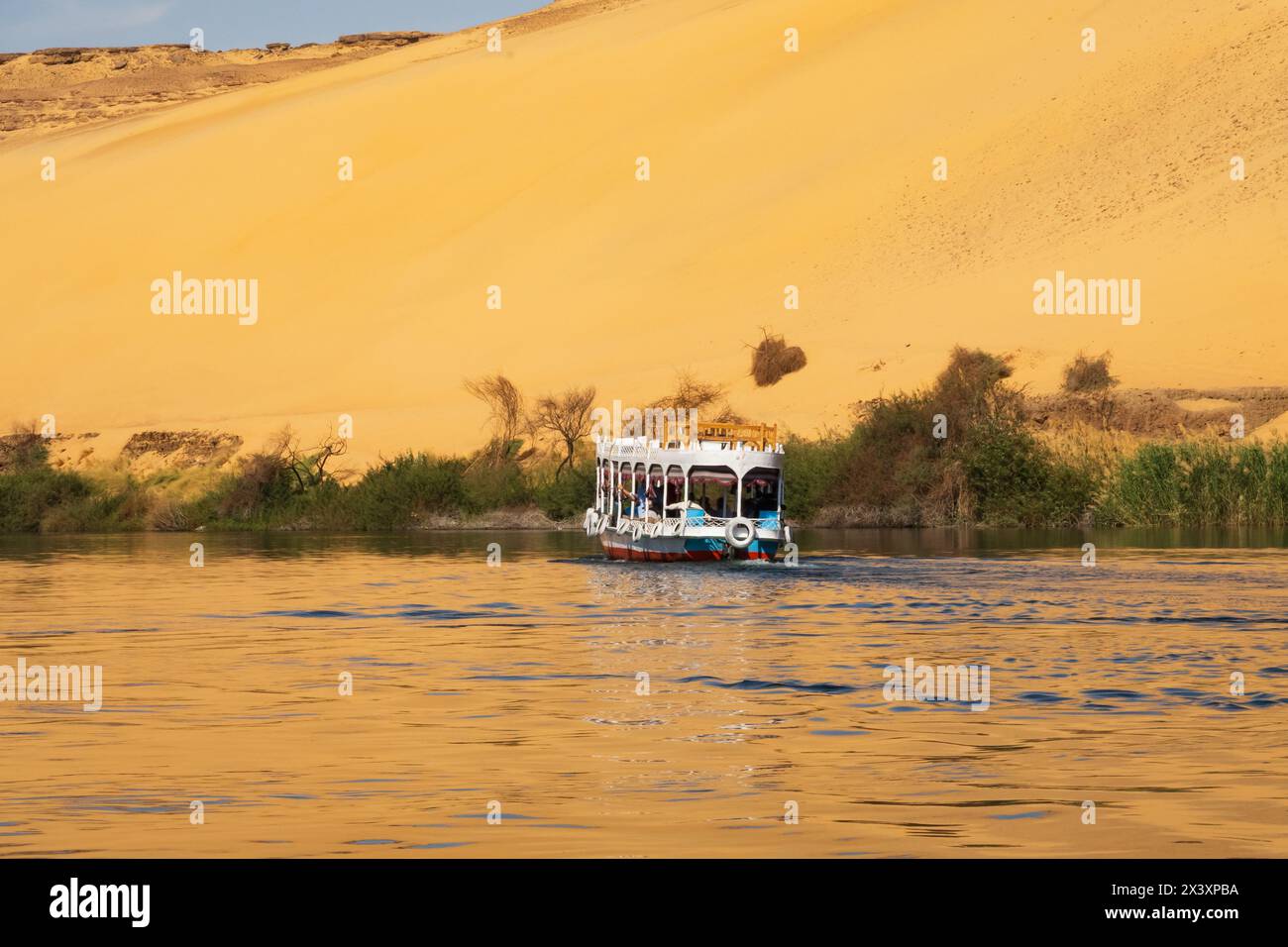 Tourist river cruise boats with the Sahara Desert and yellow reflection ...