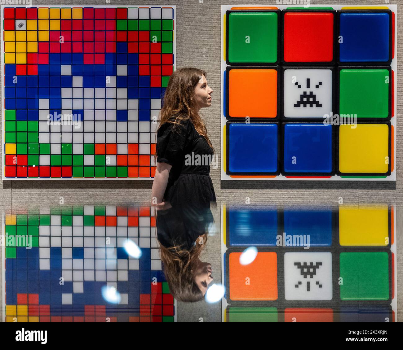 London, UK. 29 April 2024. A staff member with (L) 'Rubik Camouflage (NVDR1-2), from Rubikcubism ...