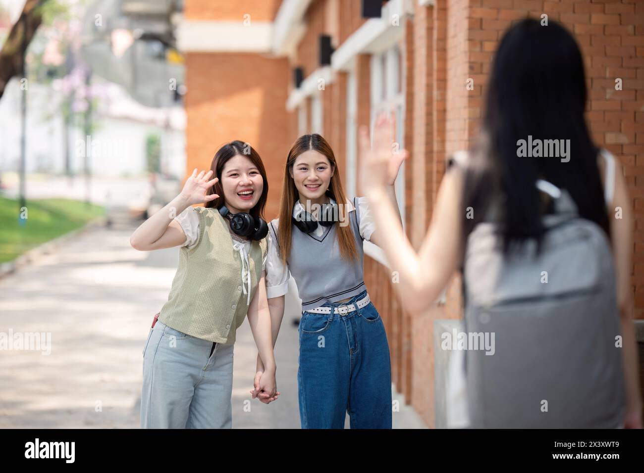 College friends walking in campus met a friend to say hello before ...