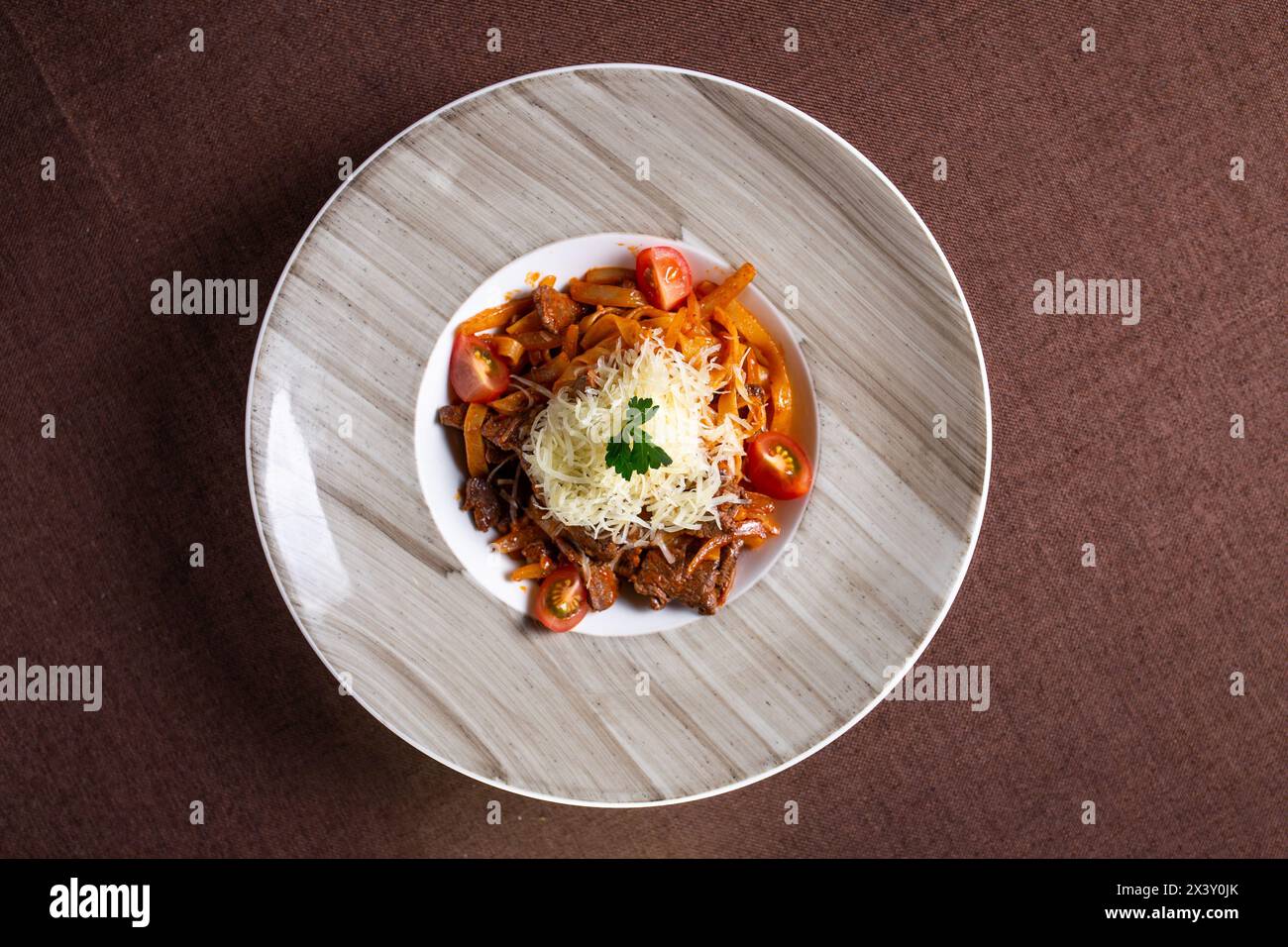 Top view of a delicious plate of beef stew with pasta, tomatoes, and ...