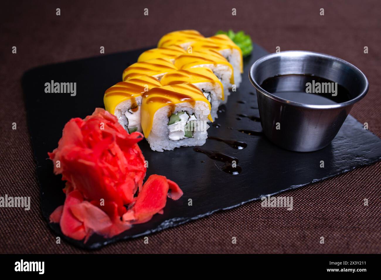 A plate of sushi with cream cheese, cucumber, and eel topped with ...