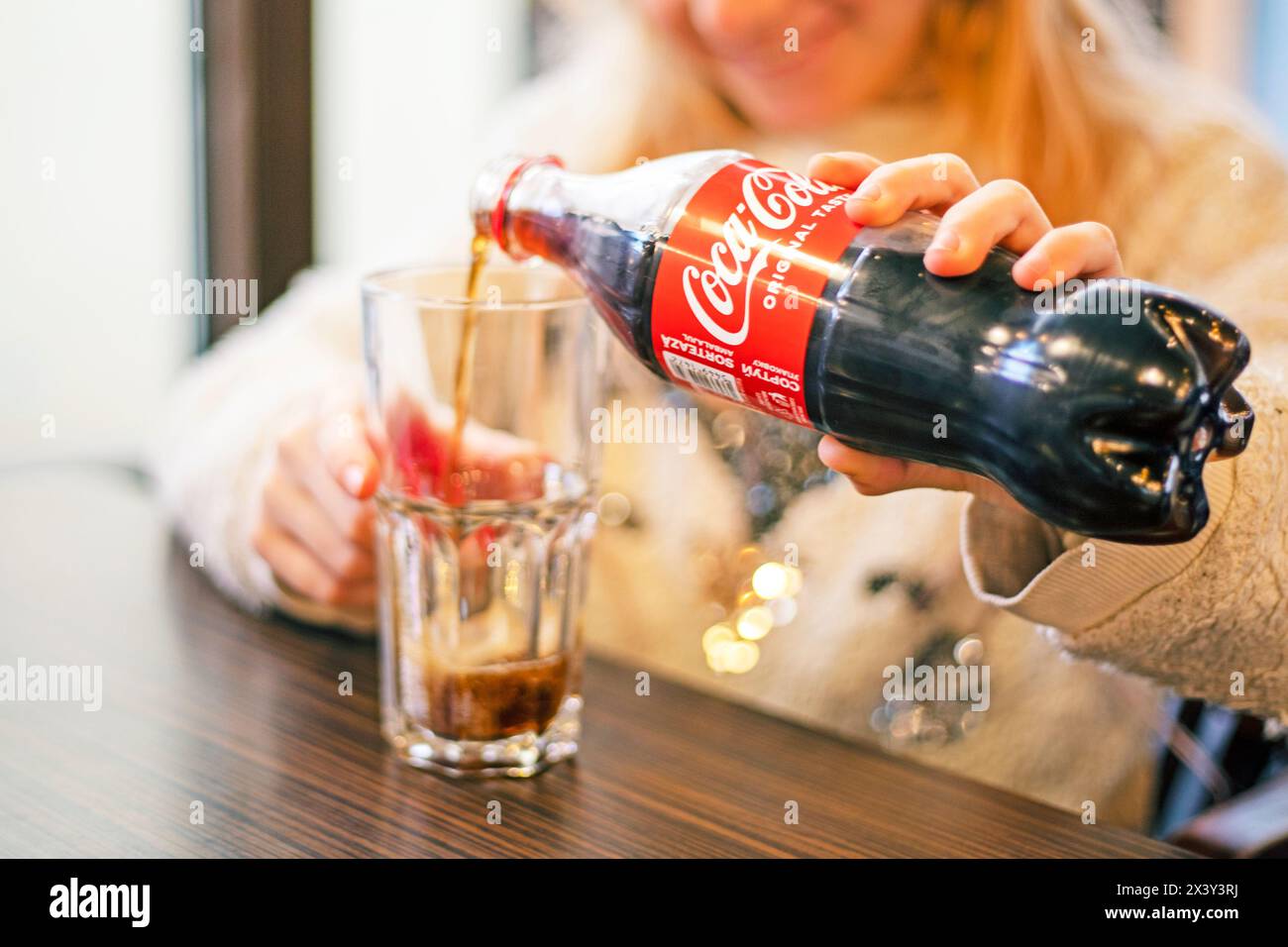 girl pours Coca-Cola into a glass in a cafe in Ivano Frankovs, Ukraine ...
