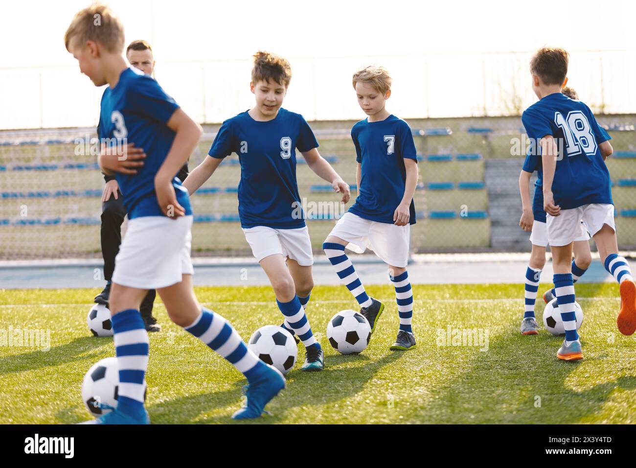 Soccer camp for kids. Boys practice dribbling in a field. Players ...