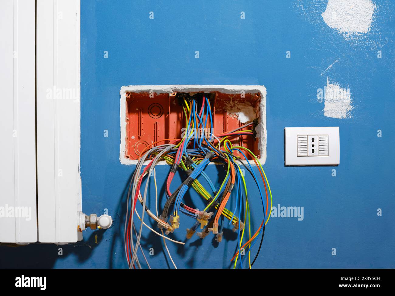 Colored electrical cables coming out of an open junction box, during ...