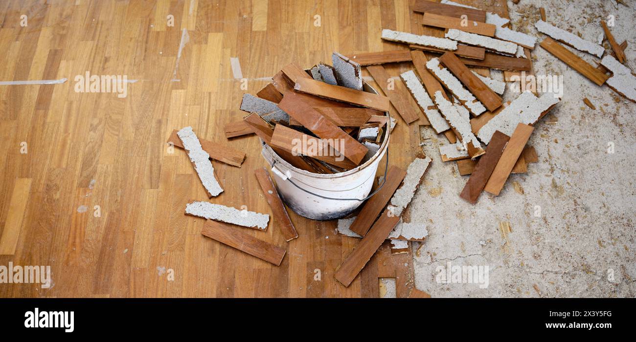 Craftsman in workwear removes the parquet flooring and fills the ...