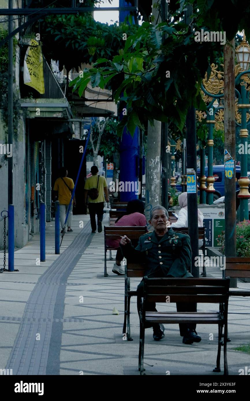 An old man in old army uniform sat on the sidewalk alone Stock Photo ...