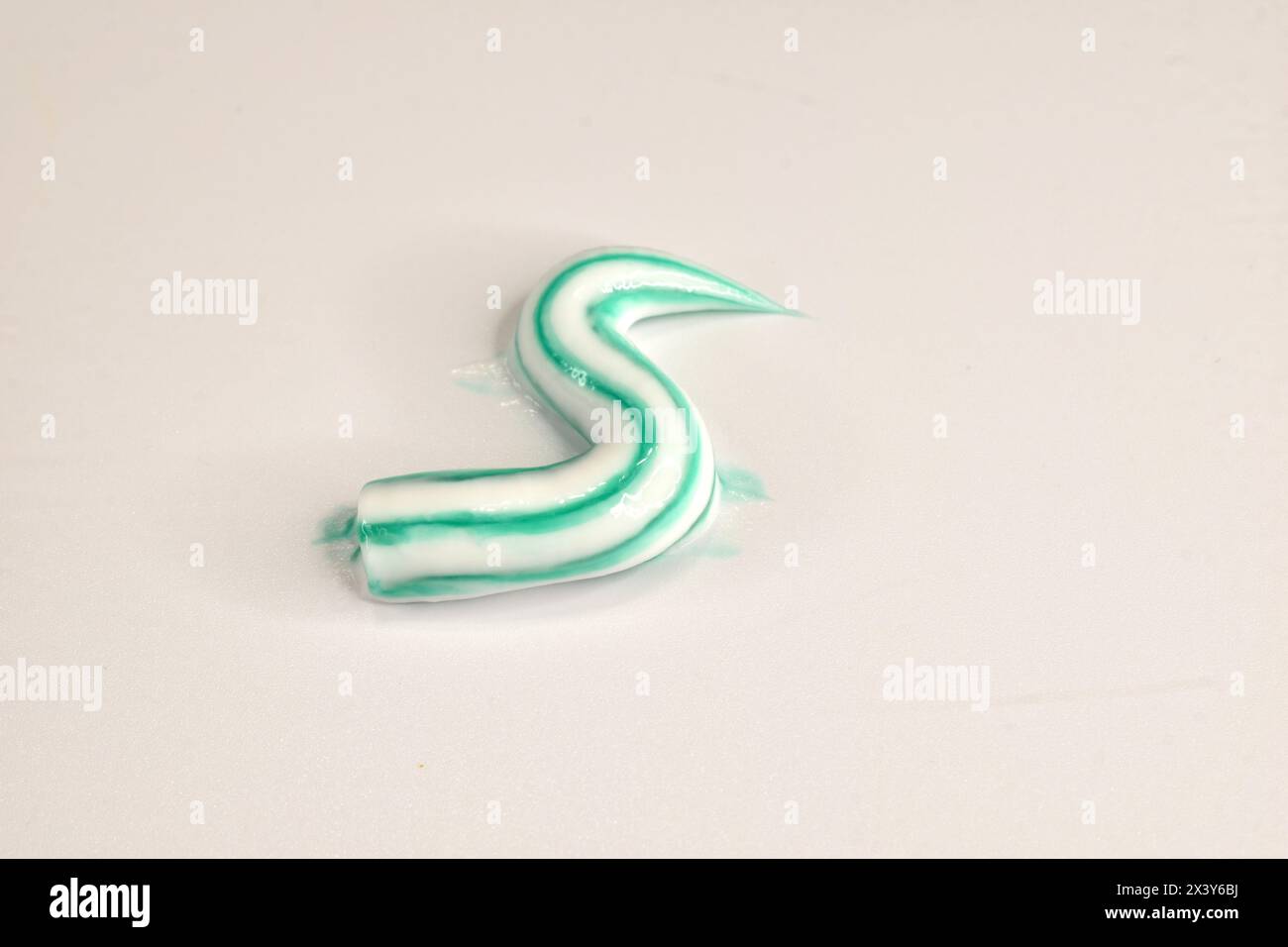 Toothpaste is squeezed out of a tube onto a white background Stock ...