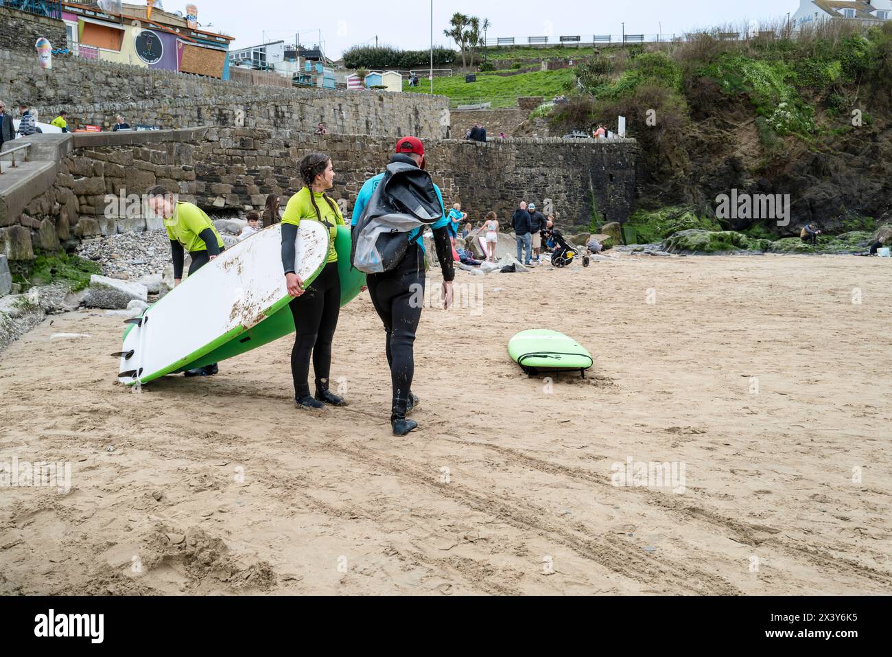 A surfing instructor from the Escape Surf School with novice surfers on ...